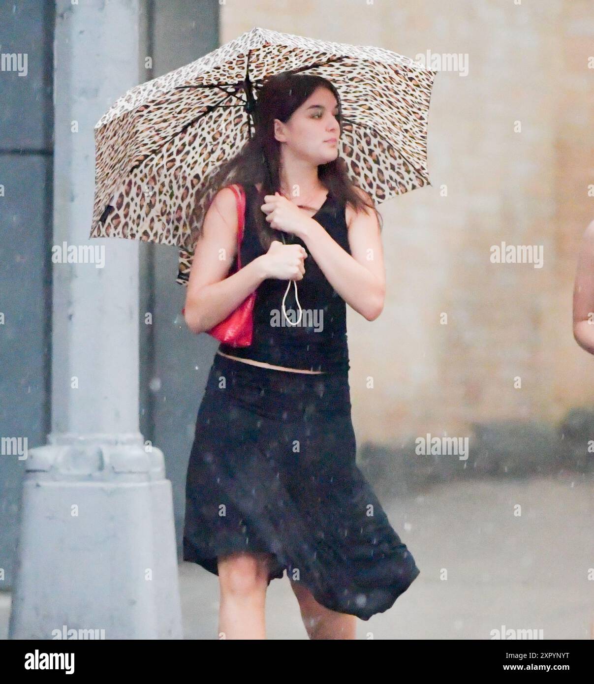 Suri Cruise hides from the rain under an umbrella as she goes for a ...
