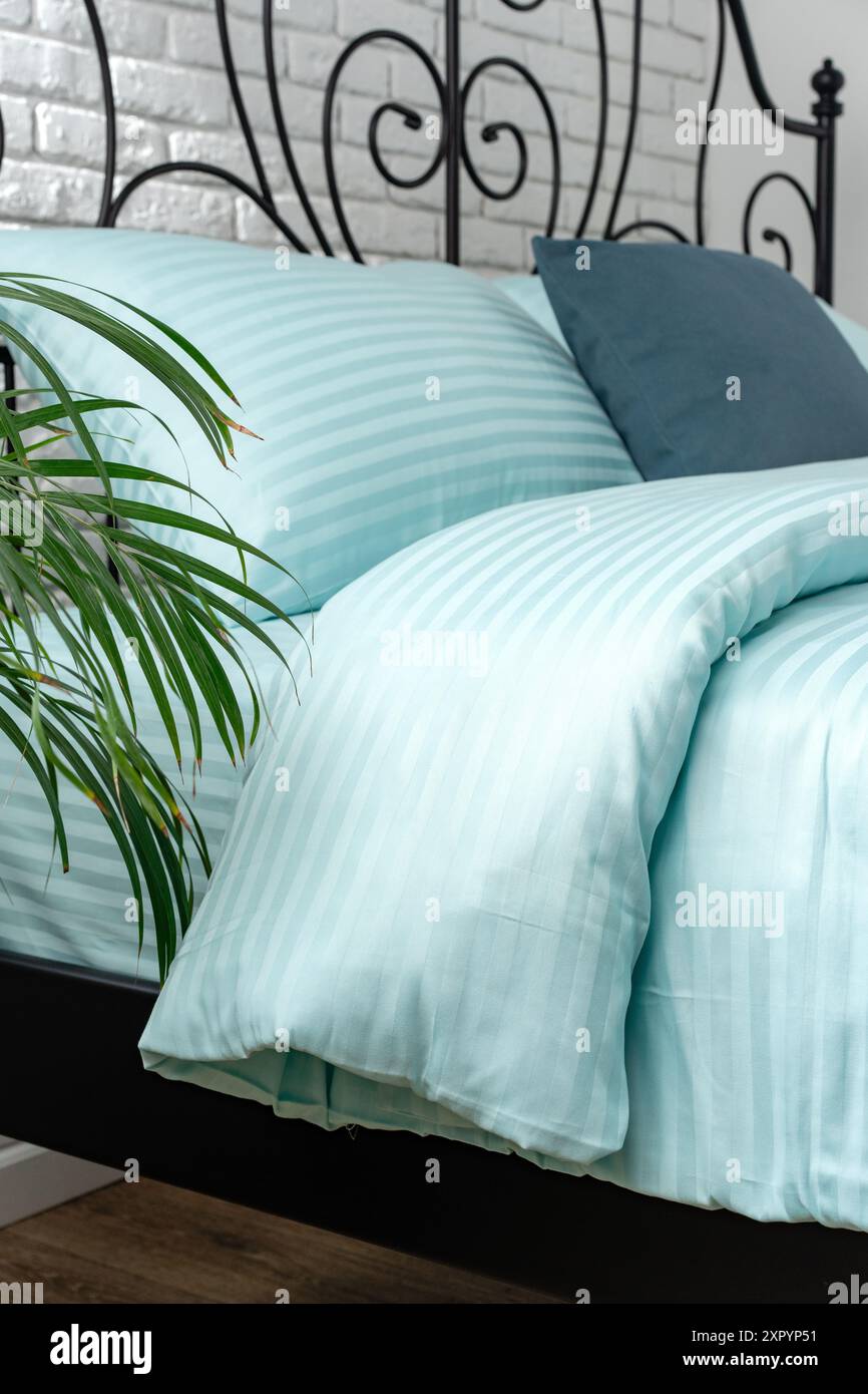 Mint Green Striped Bedding on a Black Metal Frame Bed Stock Photo - Alamy