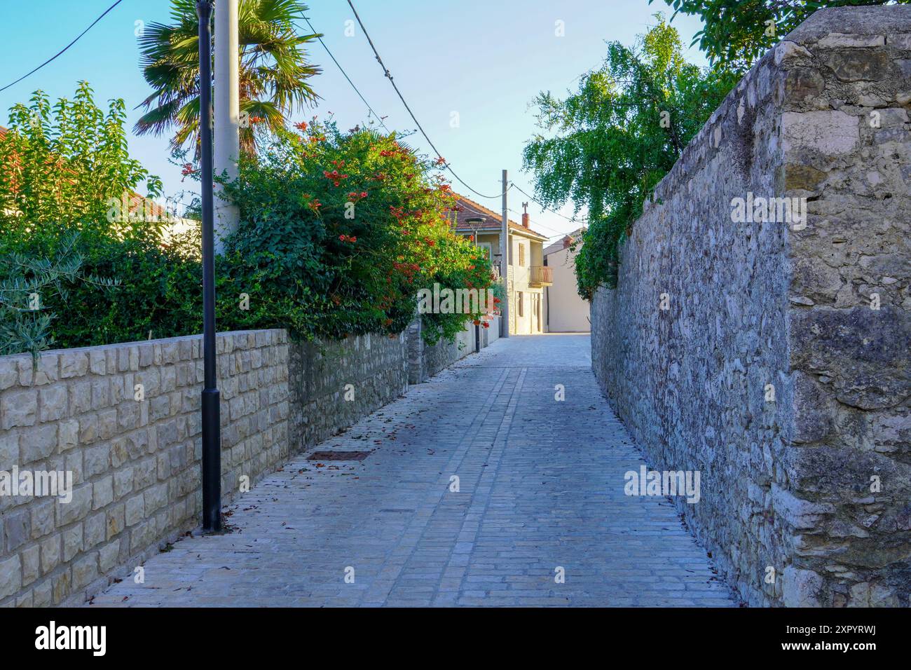 Nin, Croatia, July 24, 2024: Cobbled square and old street with stone ...