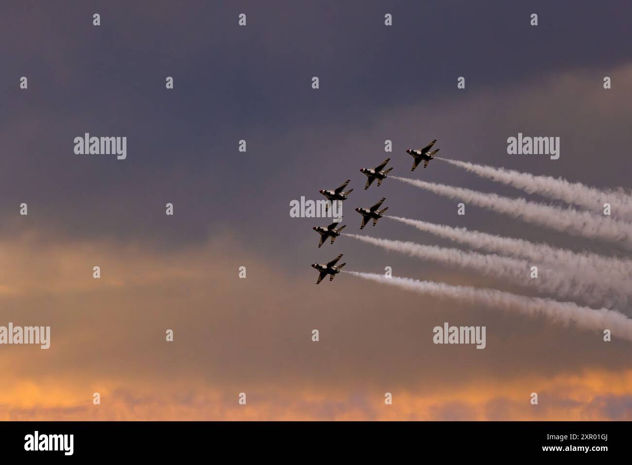 The F-16 fighter jets performing a formation maneuver during an airshow ...