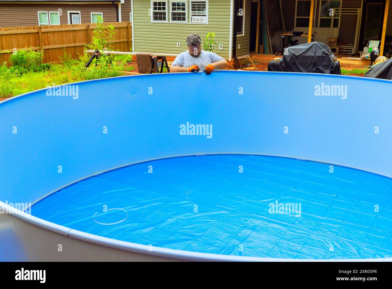An above ground pool metal frame is being installed by worker Stock ...