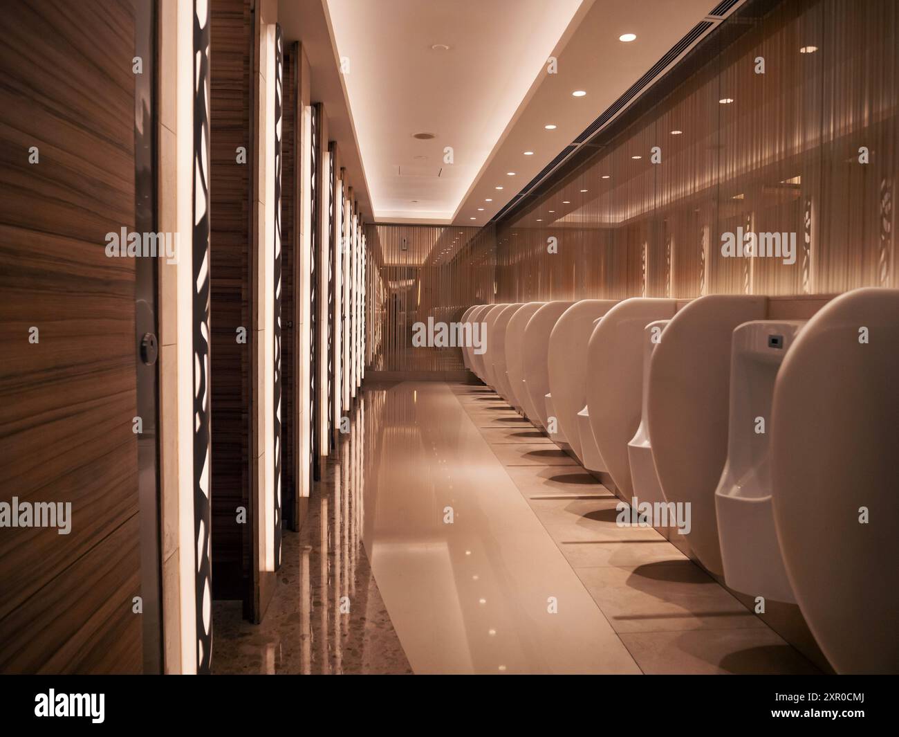 Modern public restroom with sleek white urinals and elegant lighting at ...