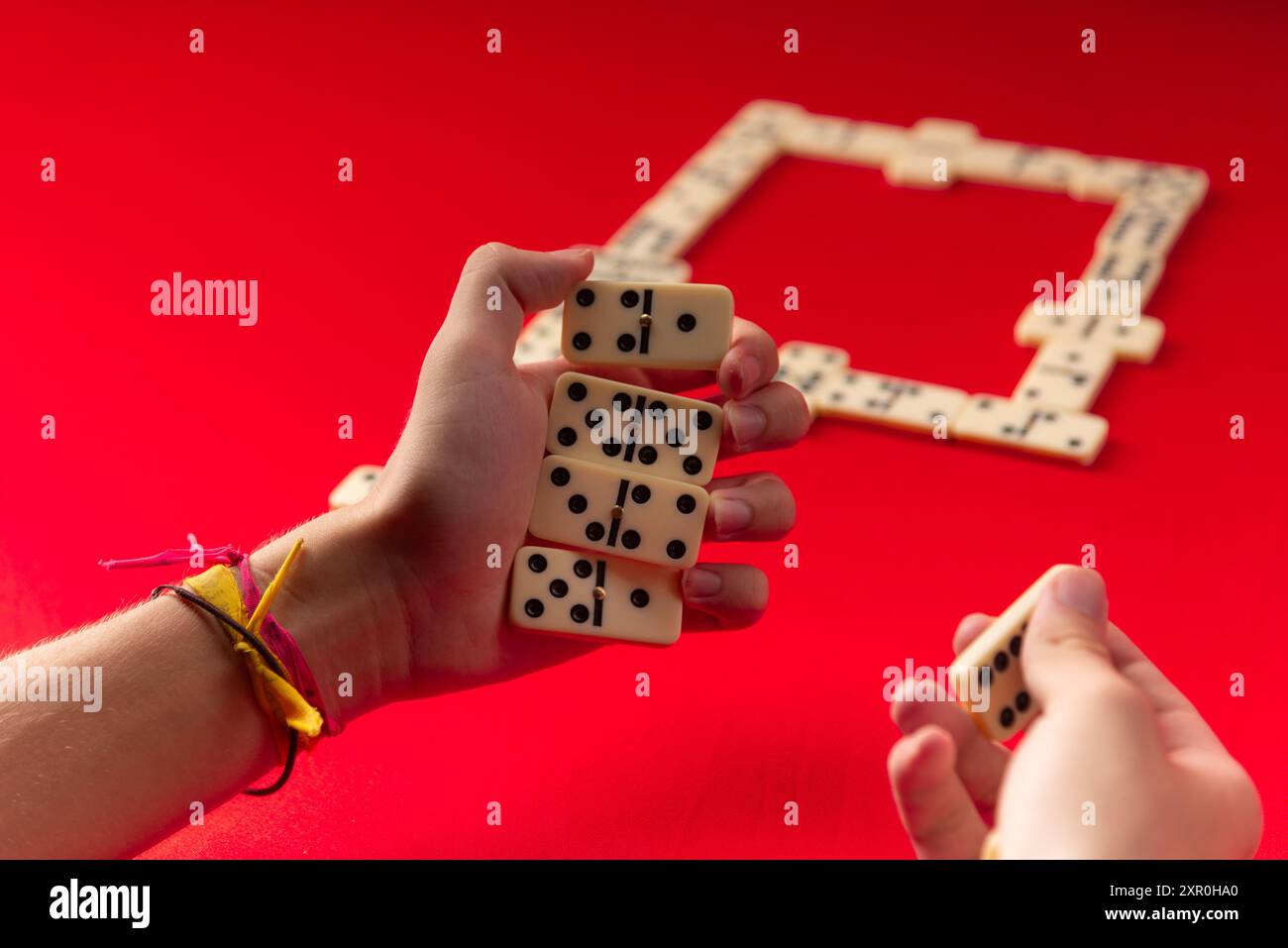 Domino players hands holding rectangular number blocks. Board game. Red ...