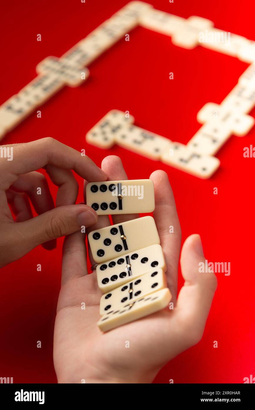 Domino players hands holding rectangular number blocks. Board game. Red ...