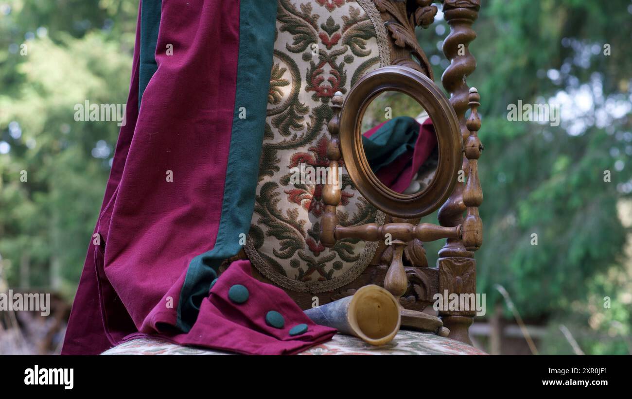 A knights chair in the garden, an old mirror, a dress Stock Photo - Alamy