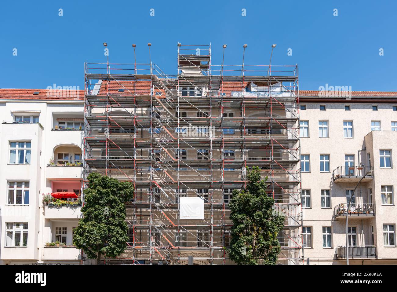 A building with scaffolding on it and a ladder on the side. The ...