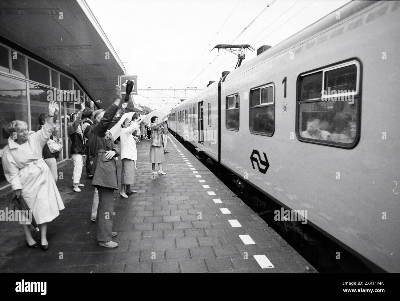 People waving on the platform to the train at Santpoort-Noord station ...