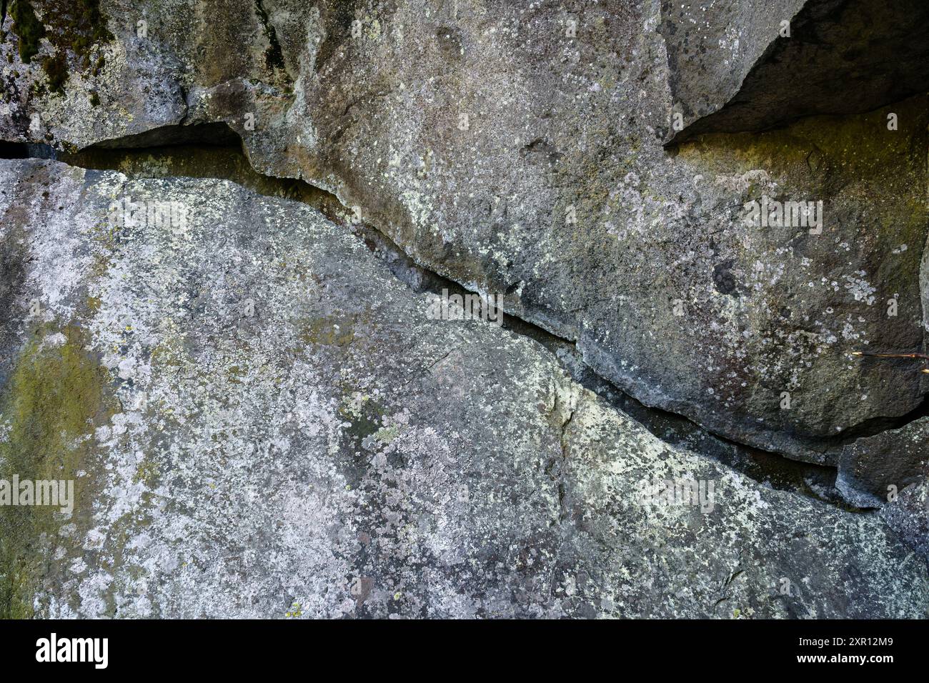 Closeup of a cracked rock face with green moss Stock Photo - Alamy