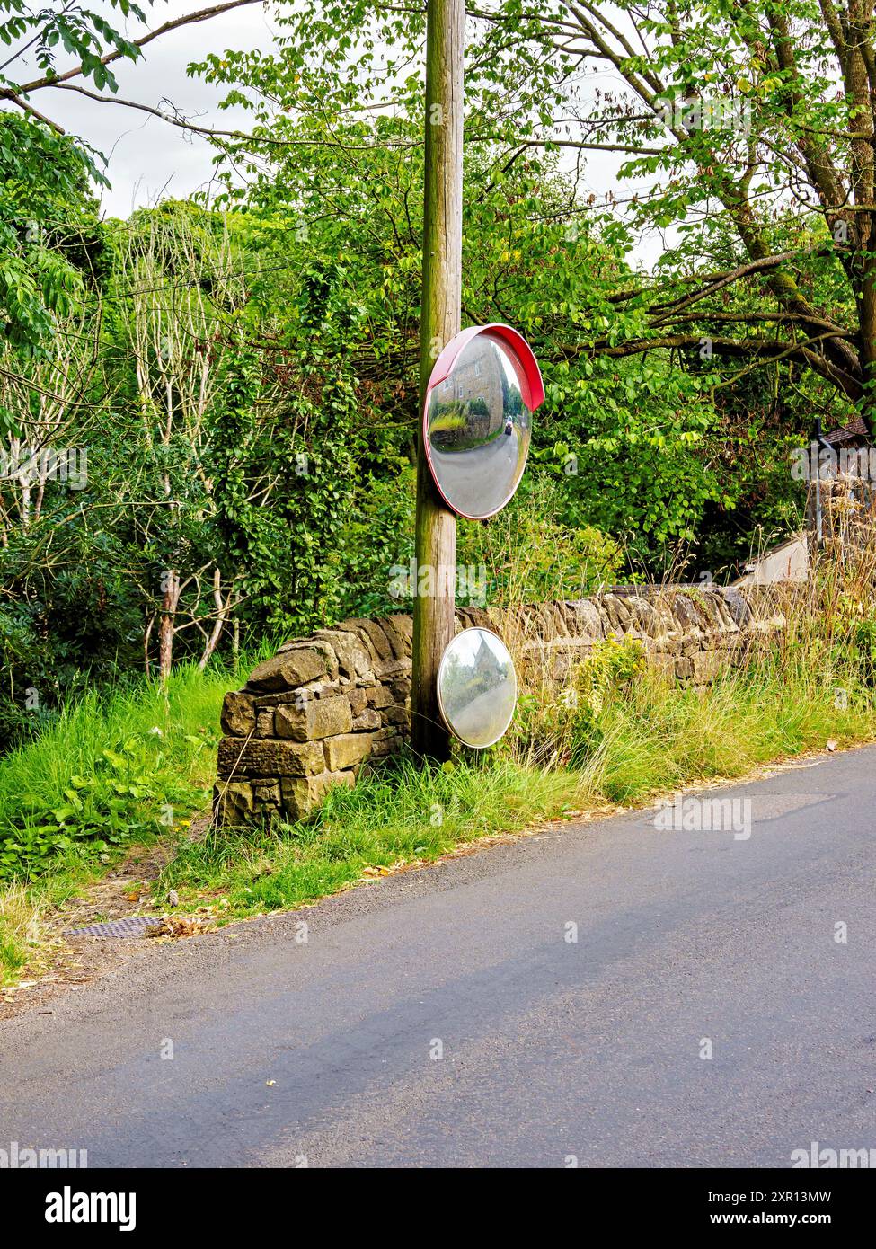 Two convex traffic mirrors mounted at a rural road intersection ...