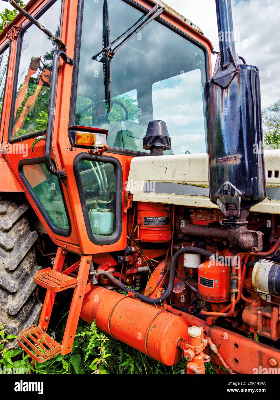 Close-up of a vintage red tractor in a field, showcasing intricate ...