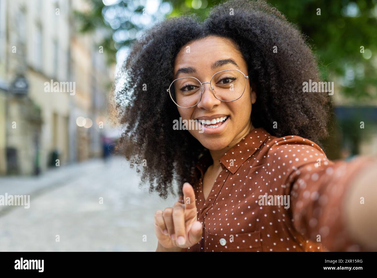 Happy woman smiling and making a video call outdoors using her phone ...