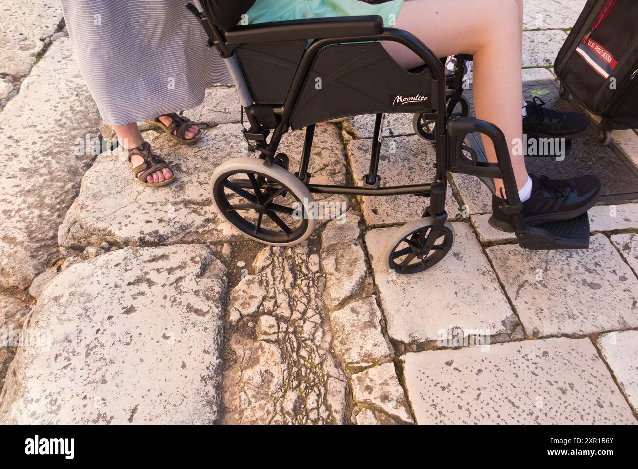 Carer pushing disabled daughter in wheelchair / wheel chair on Roman ...