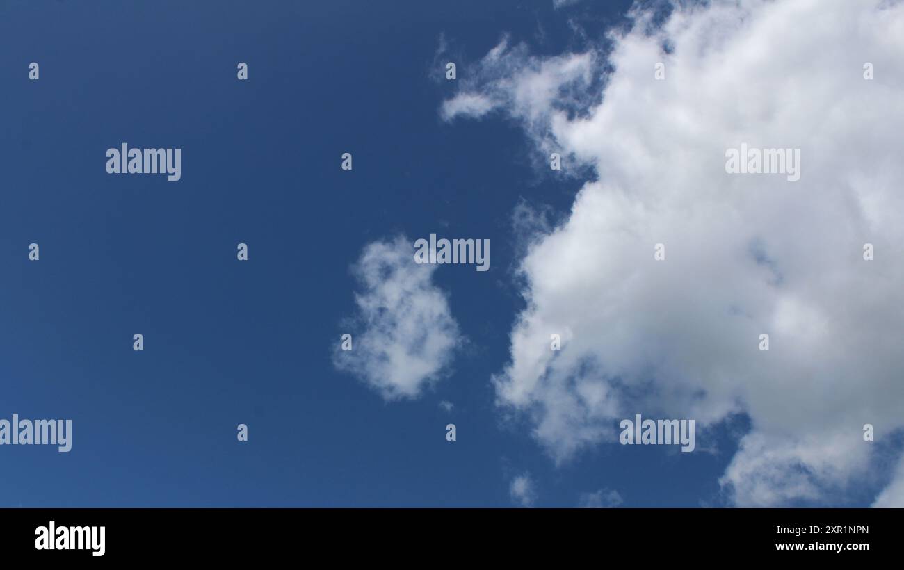 Clouds against a vivid blue sky on a summers day in June in the UK ...