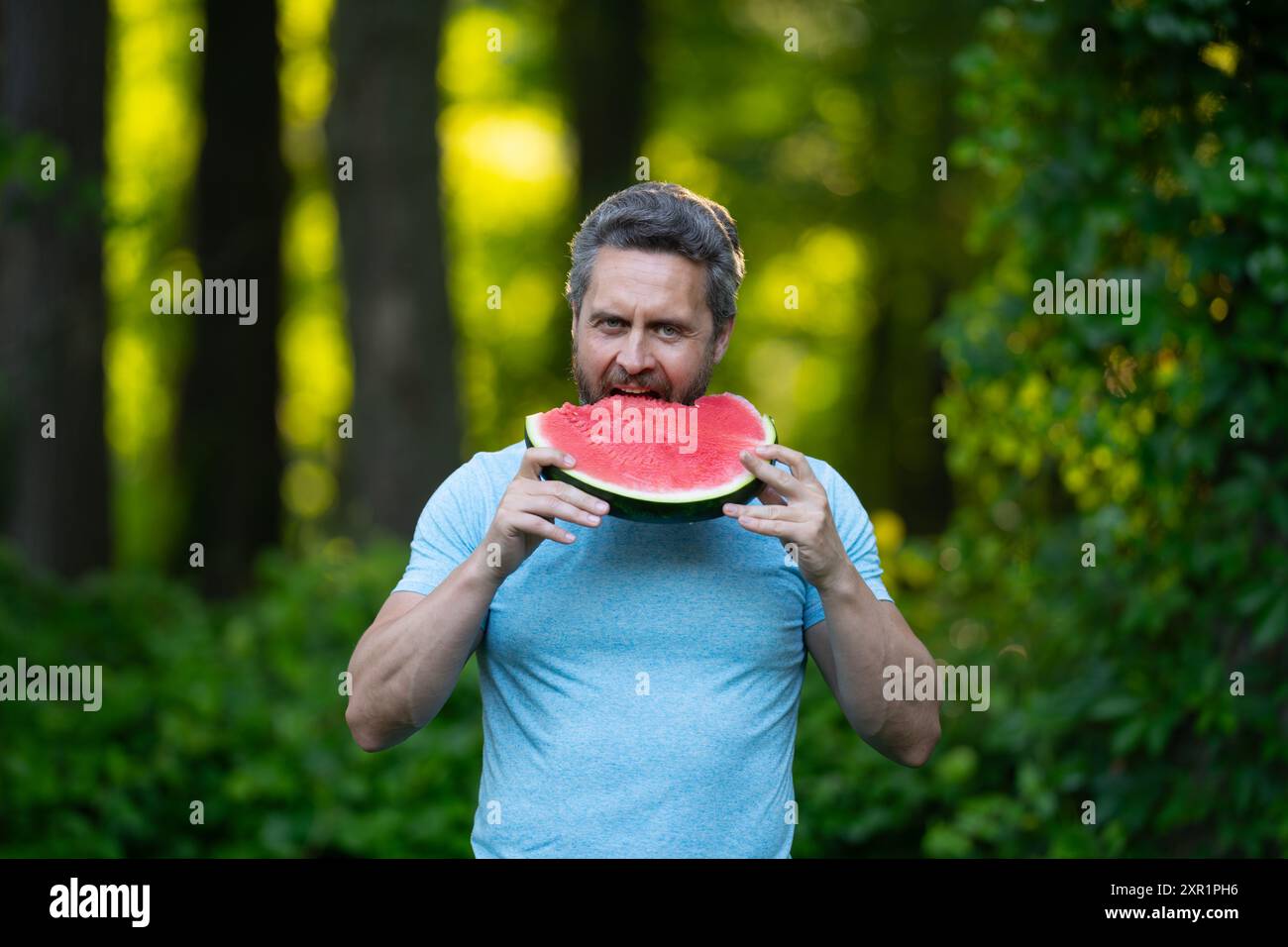 Male face with watermelon, close up. Funny man eating watermelon ...