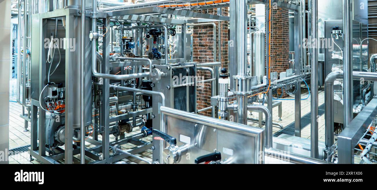 Modern brewery with extensive stainless steel piping and tanks ...