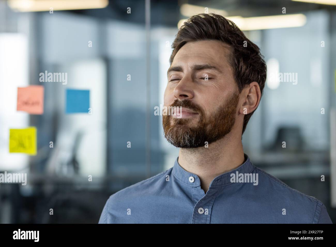 Office worker with beard practicing mindfulness and relaxation in ...