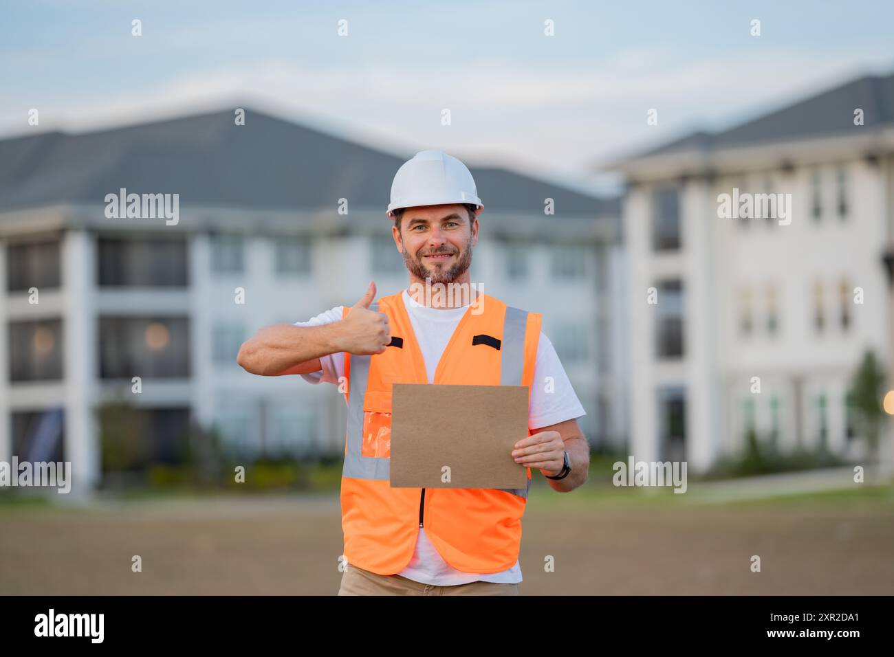 Engineer hold paper board for text. Builder showing signboard placard ...