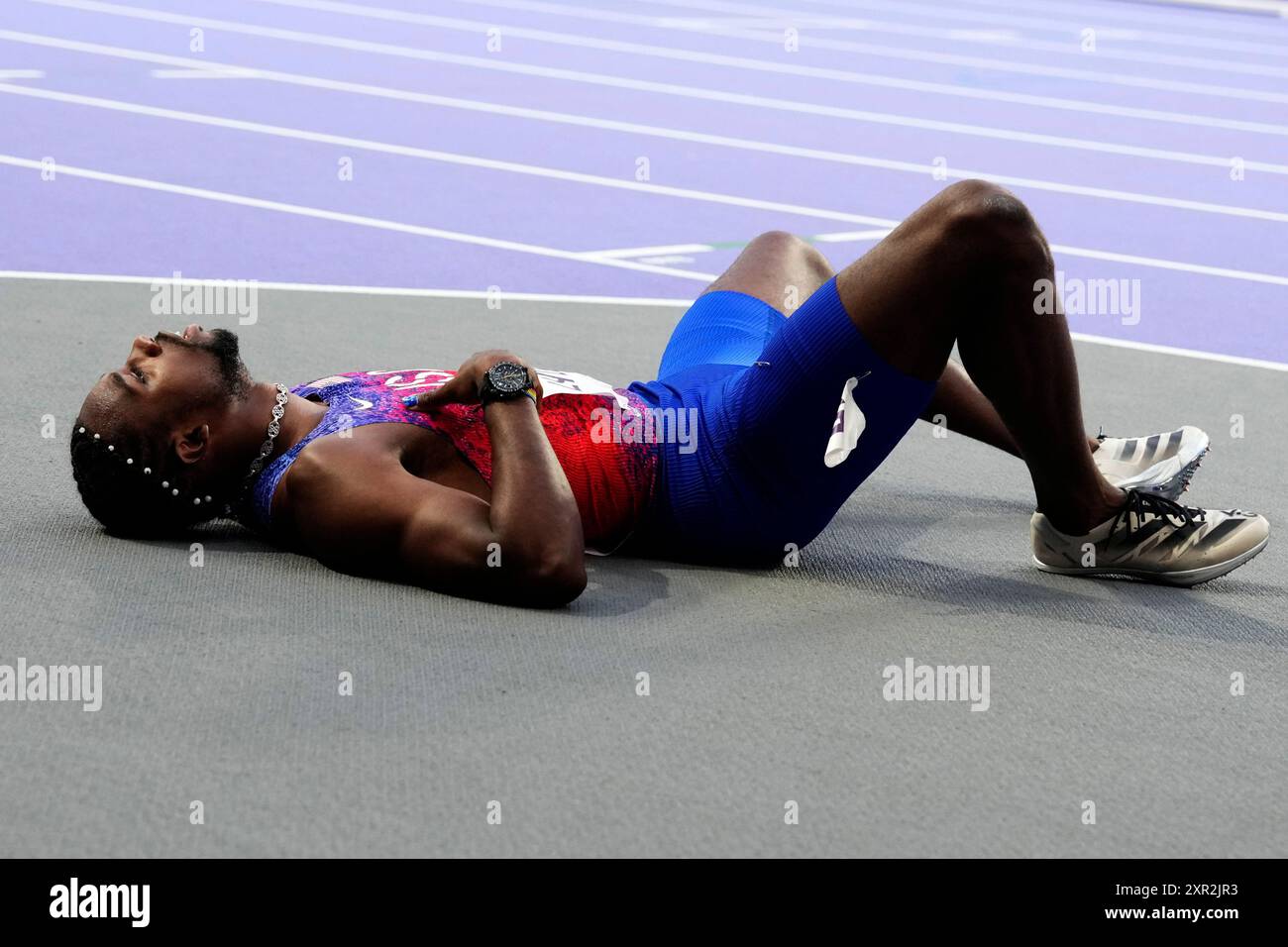 Noah Lyles, of the United States, lies on the track following the men's ...