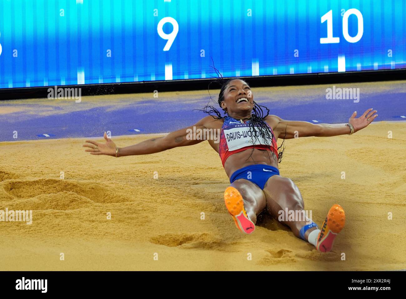 Tara Davis-Woodhall, of the United States, falls backwards into the pit ...