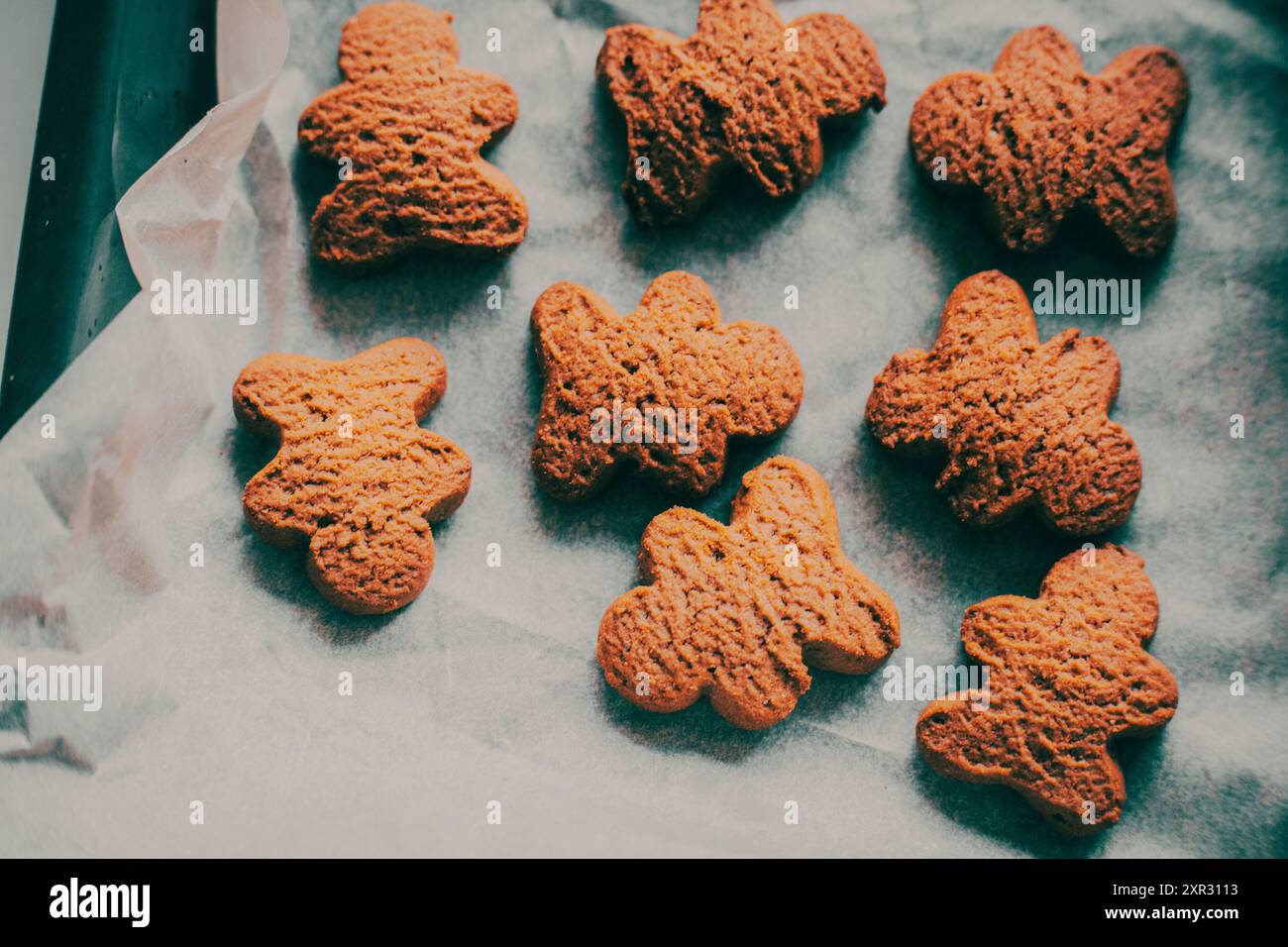 Gingerbread figures are lying on the baking paper. Homemade treats for ...