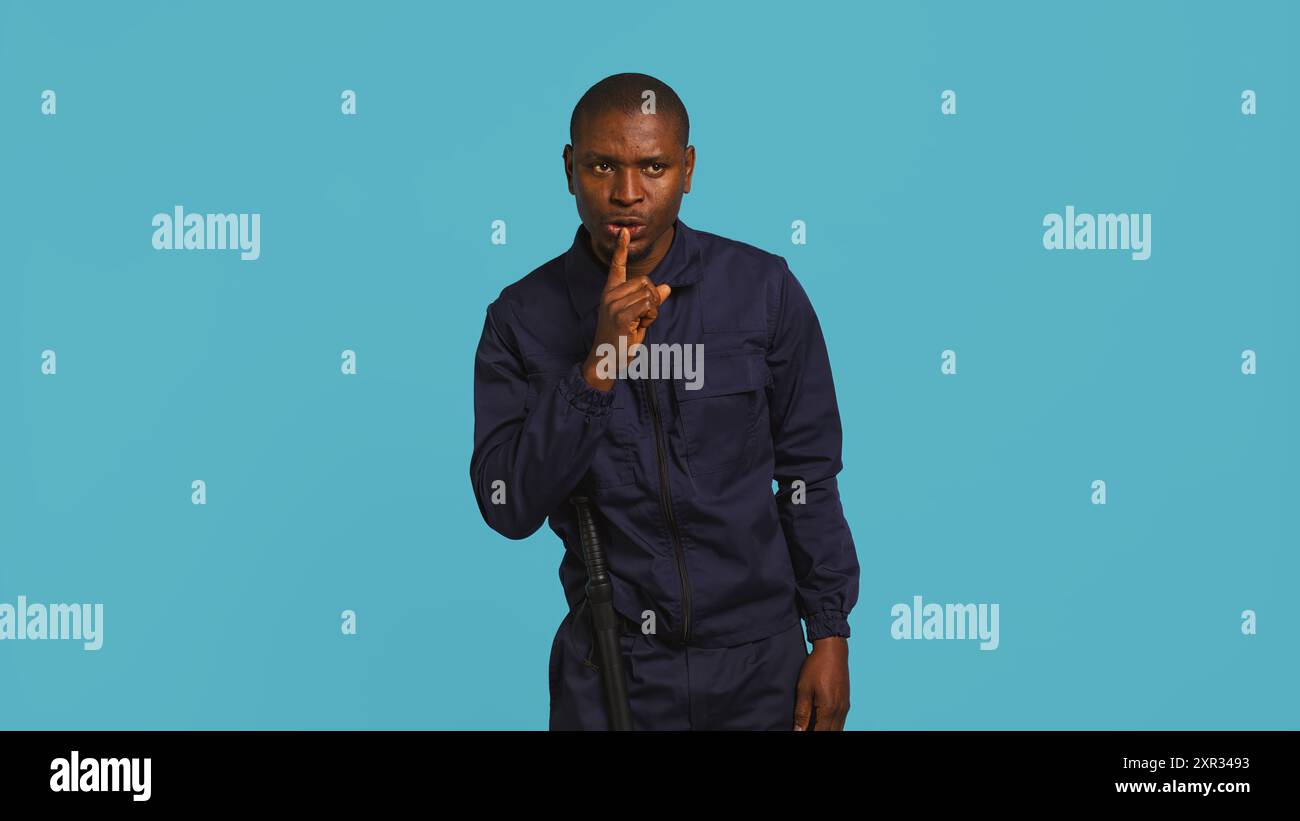 Security guard doing shush sign gesturing with finger, preventing ...