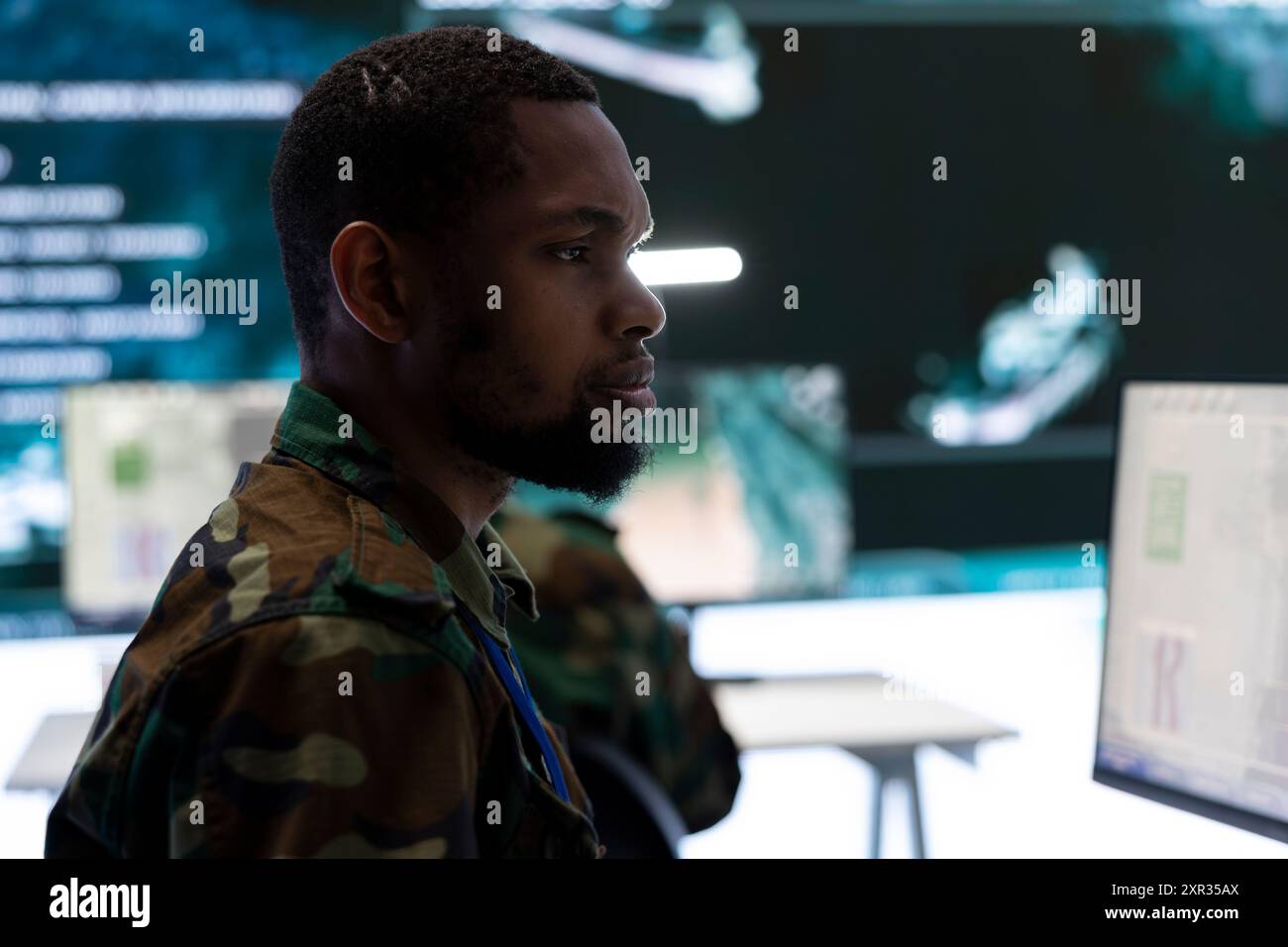 Military personnel in a high tech command center monitor satellite ...