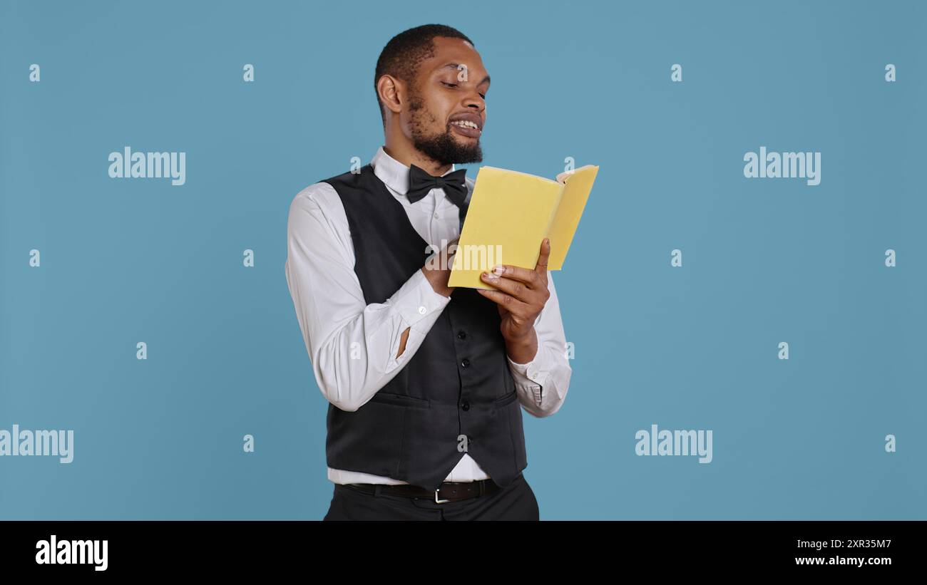 Doorkeeper classy staff enjoying a literature book against blue ...
