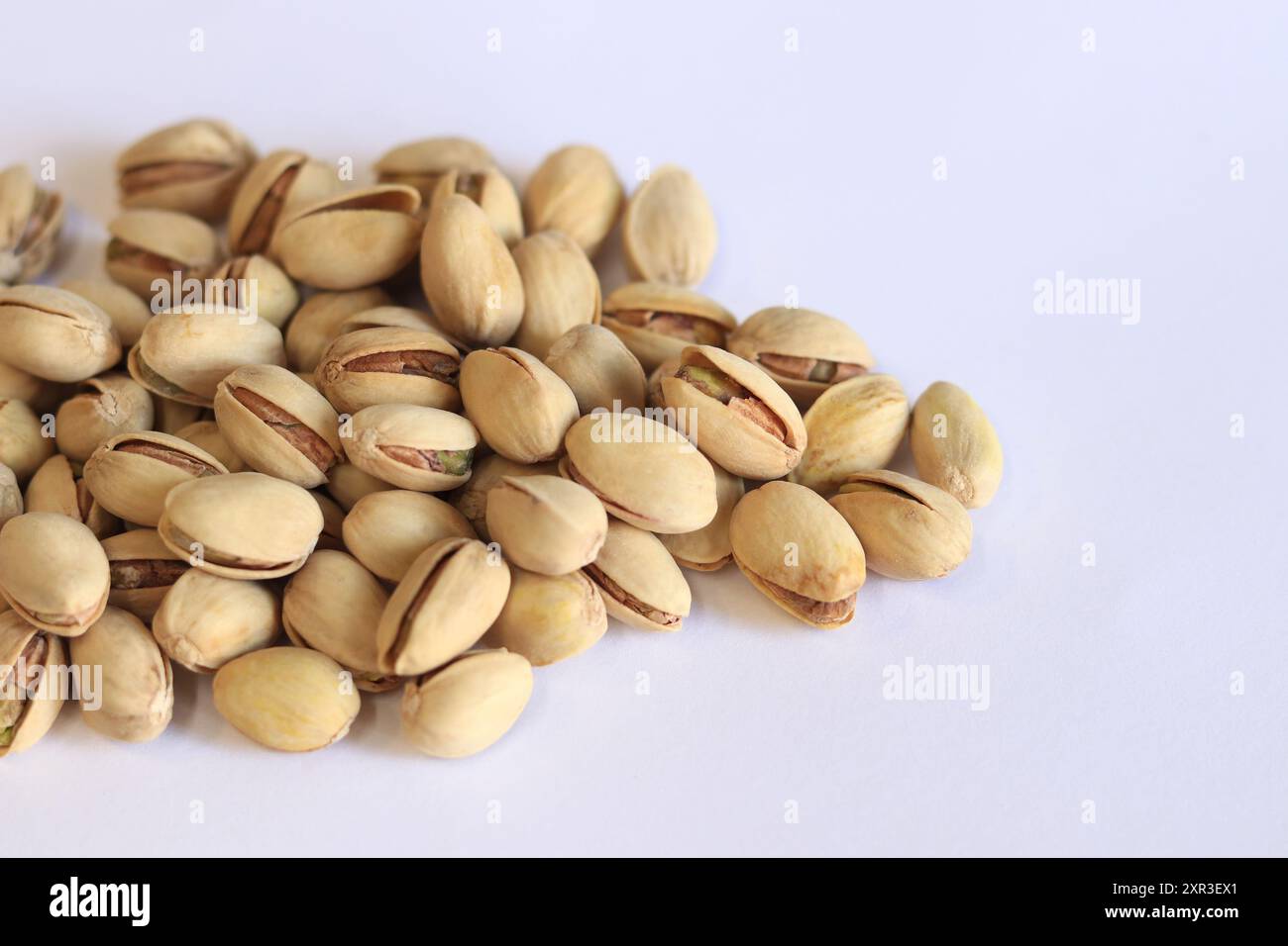 Pistachios on a white background. A handful of dry salted pistachios on a light background ...