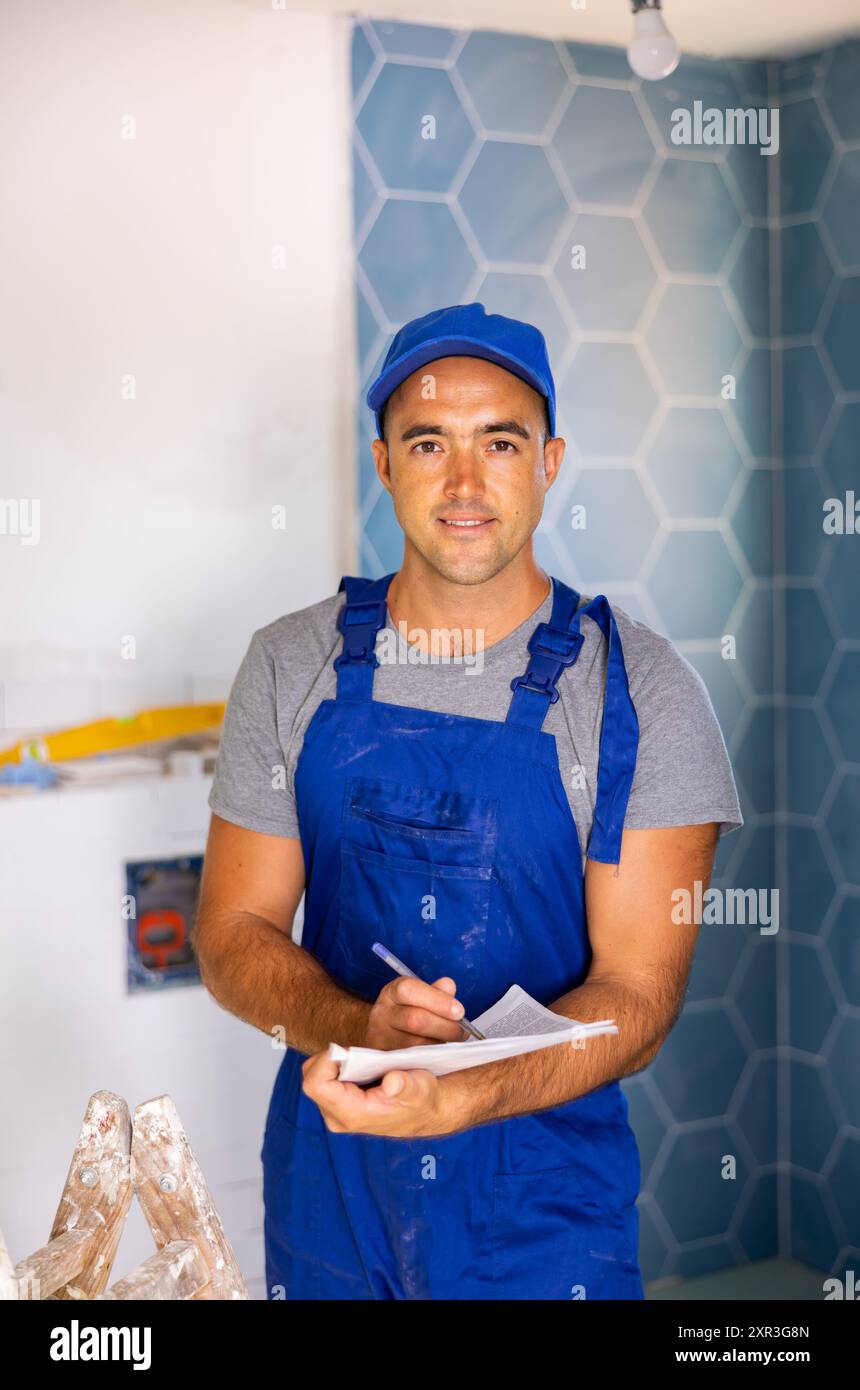 Professional builder in overalls checks hi-res stock photography and ...