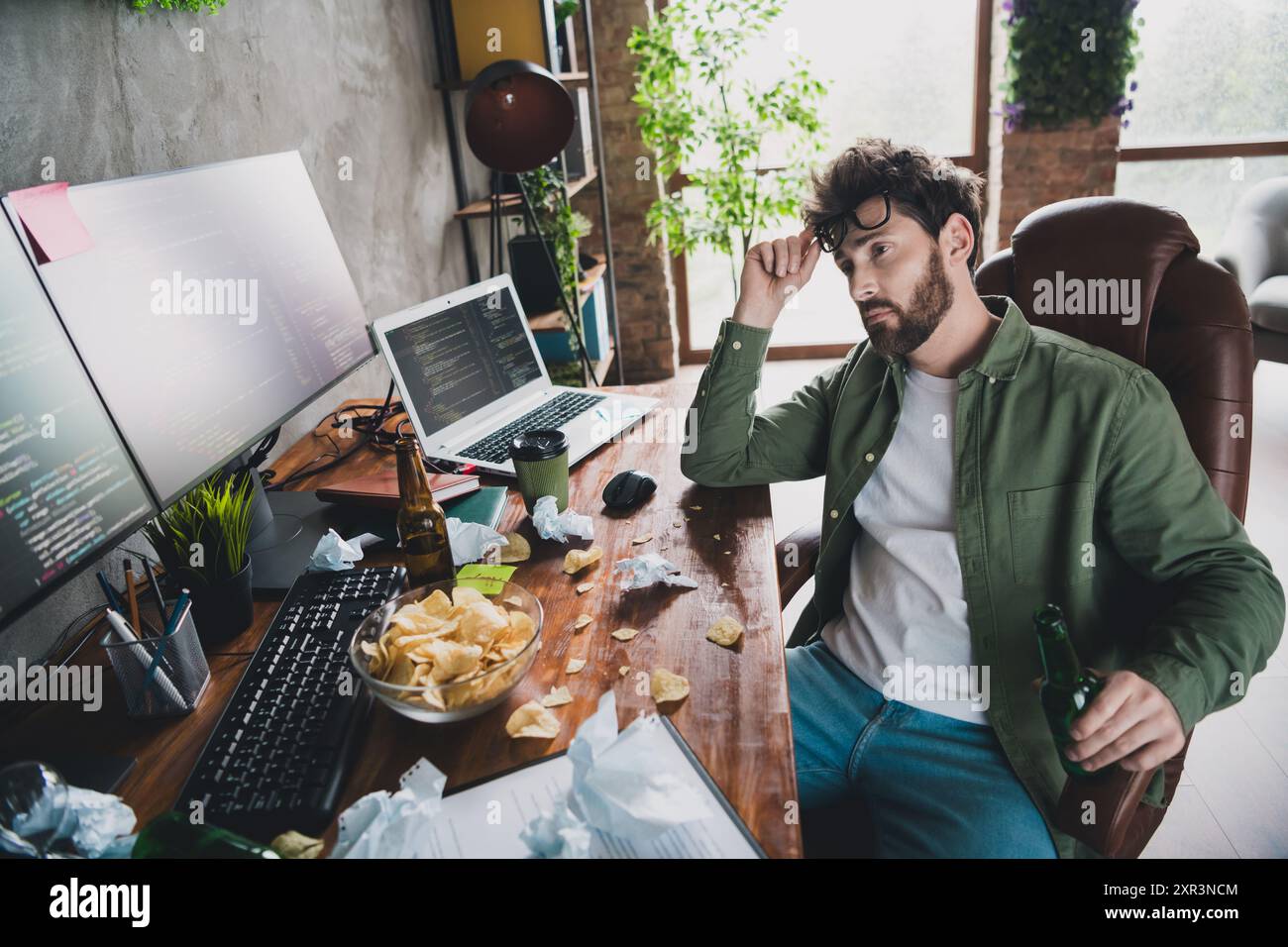 Photo of professional it specialist young man beer messy computer ...