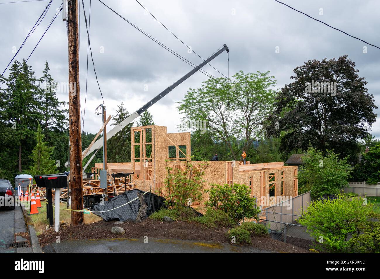 Residential house construction, boom crane lifting lumber delivery ...