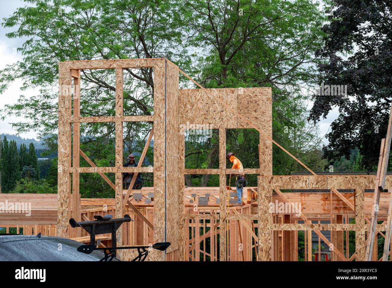 Residential house construction, boom crane lifting lumber delivery ...