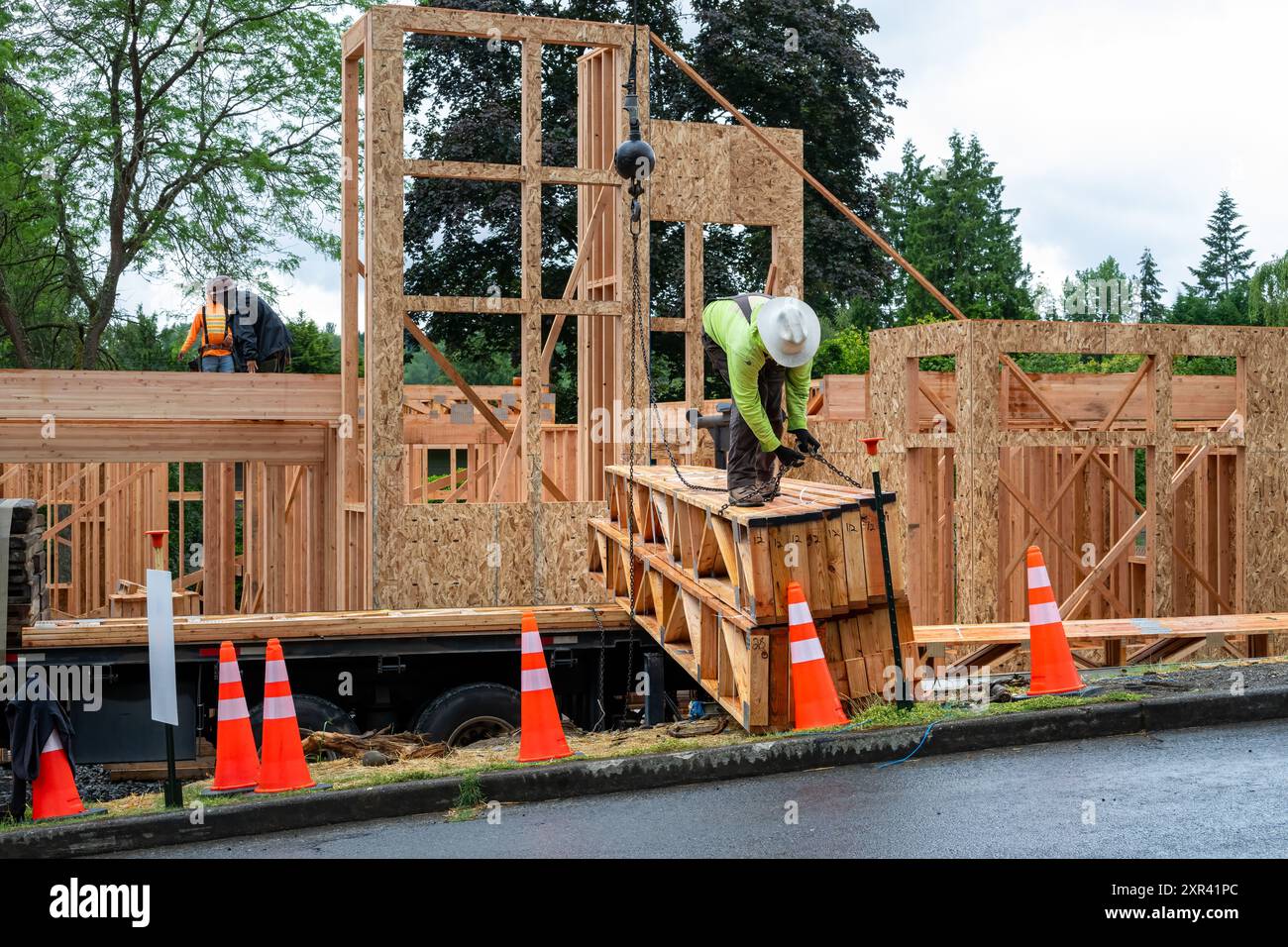 Residential house construction, boom crane truck delivering lumber to ...