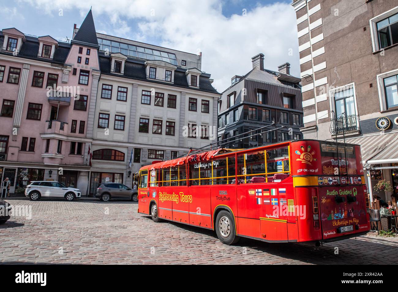 This image depicts a sightseeing bus touring the city center of Riga ...