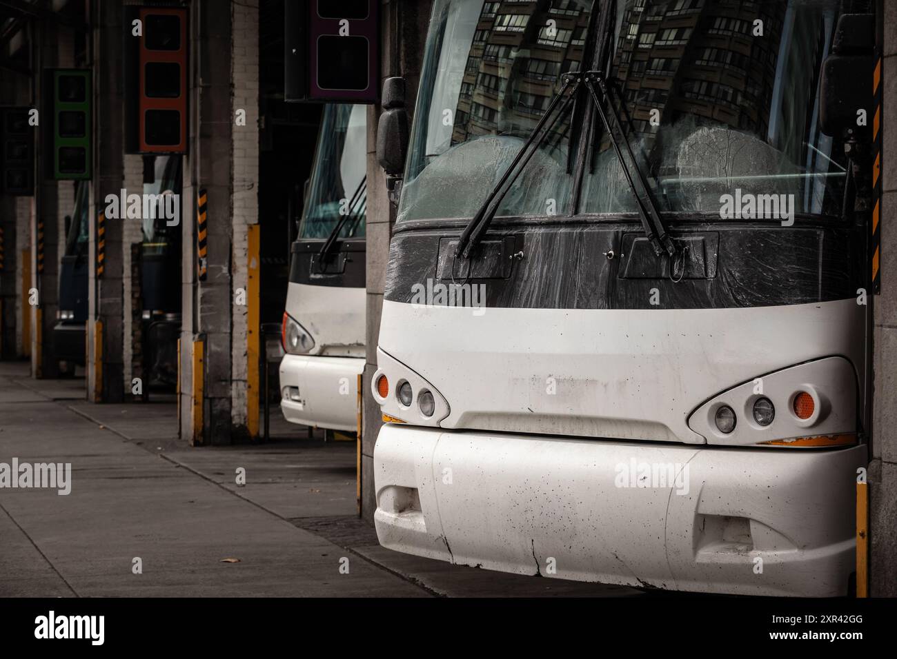 This image showcases long distance buses parked at a bus terminal in a ...