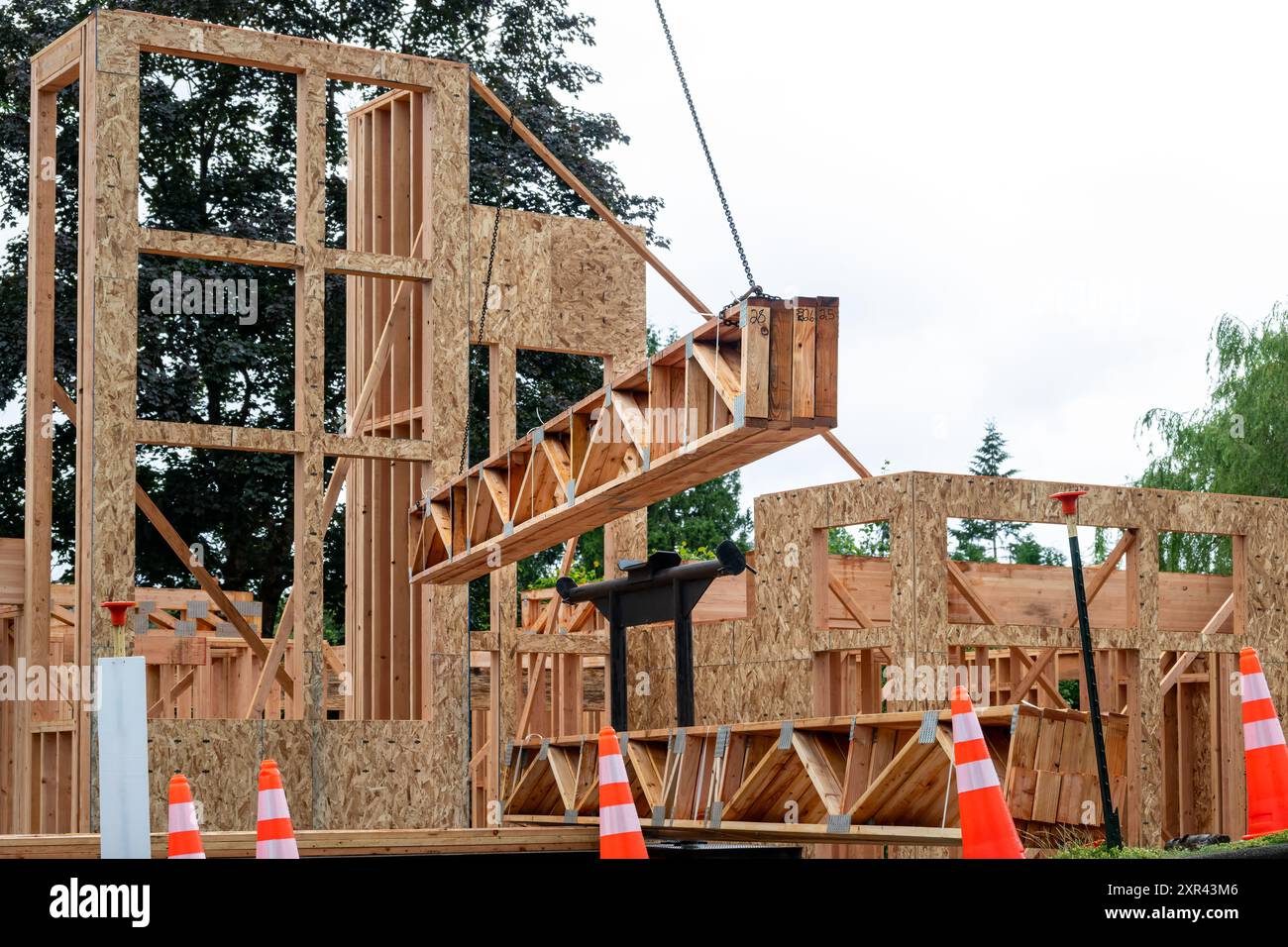 Residential house construction, boom crane lifting lumber delivery ...