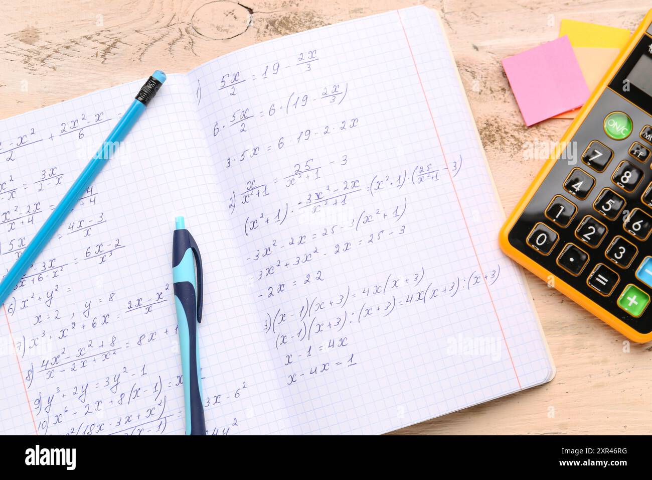 Copybook with maths formulas, calculator and stationery on beige wooden ...