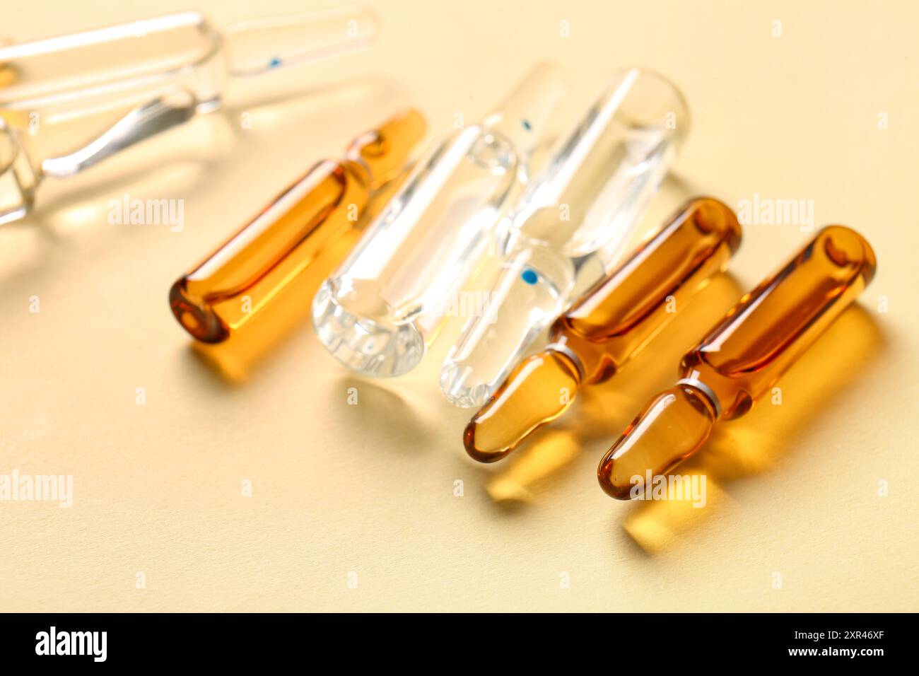 Glass medical ampules on light yellow background Stock Photo - Alamy