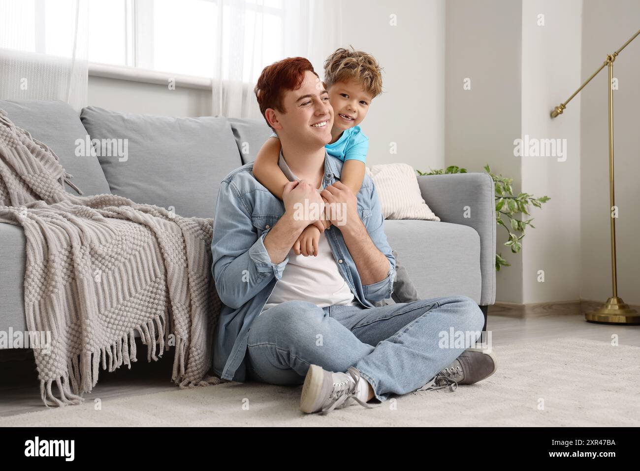 Little boy hugging his father at home Stock Photo - Alamy