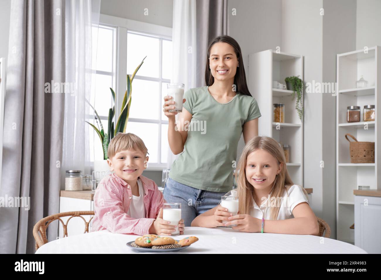 Happy family drinking milk at dining table in kitchen Stock Photo - Alamy