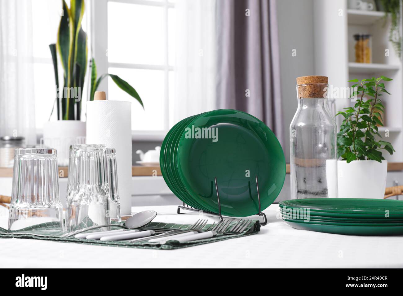 Set of clean dishes and glasses on dining table in kitchen Stock Photo ...