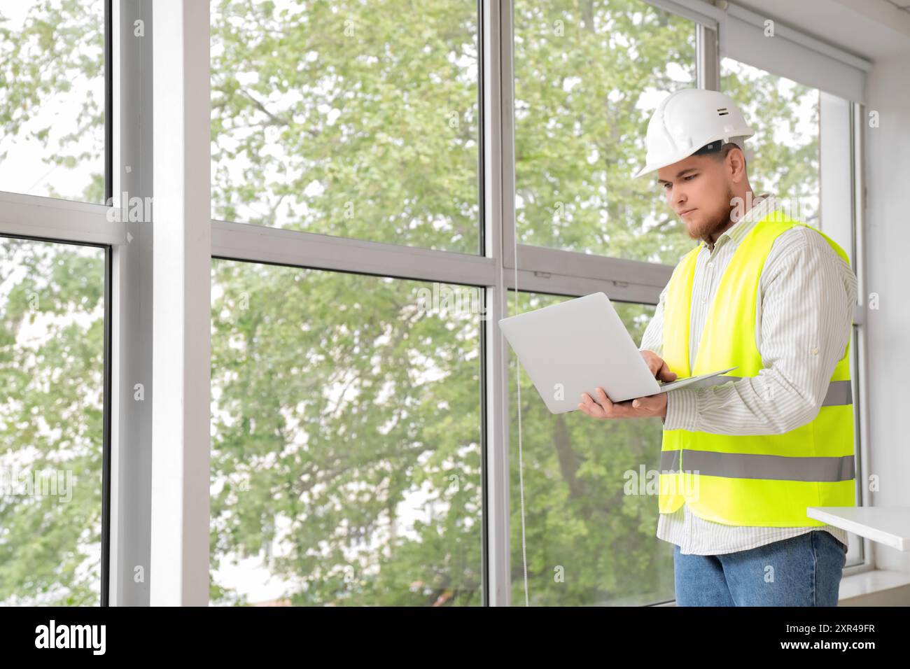 Male contractor working with laptop in room Stock Photo - Alamy
