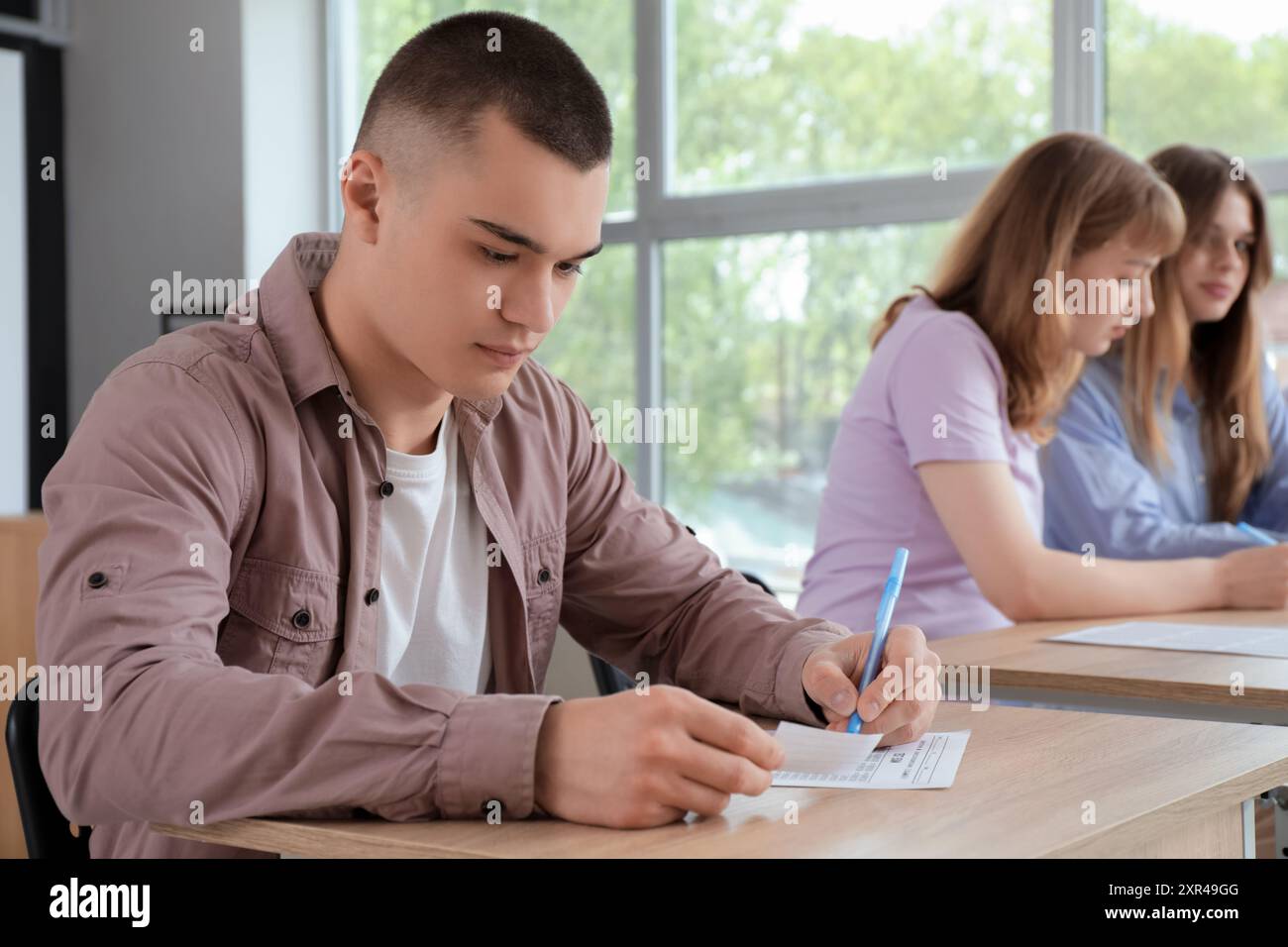 Male student cheating on exam in classroom Stock Photo - Alamy