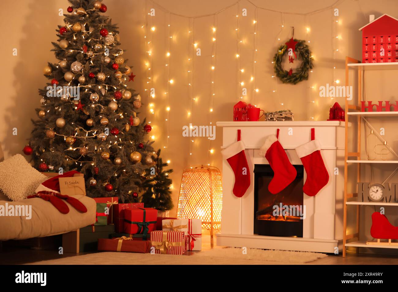 Stylish room with fireplace, Christmas tree, shelving unit and gift ...