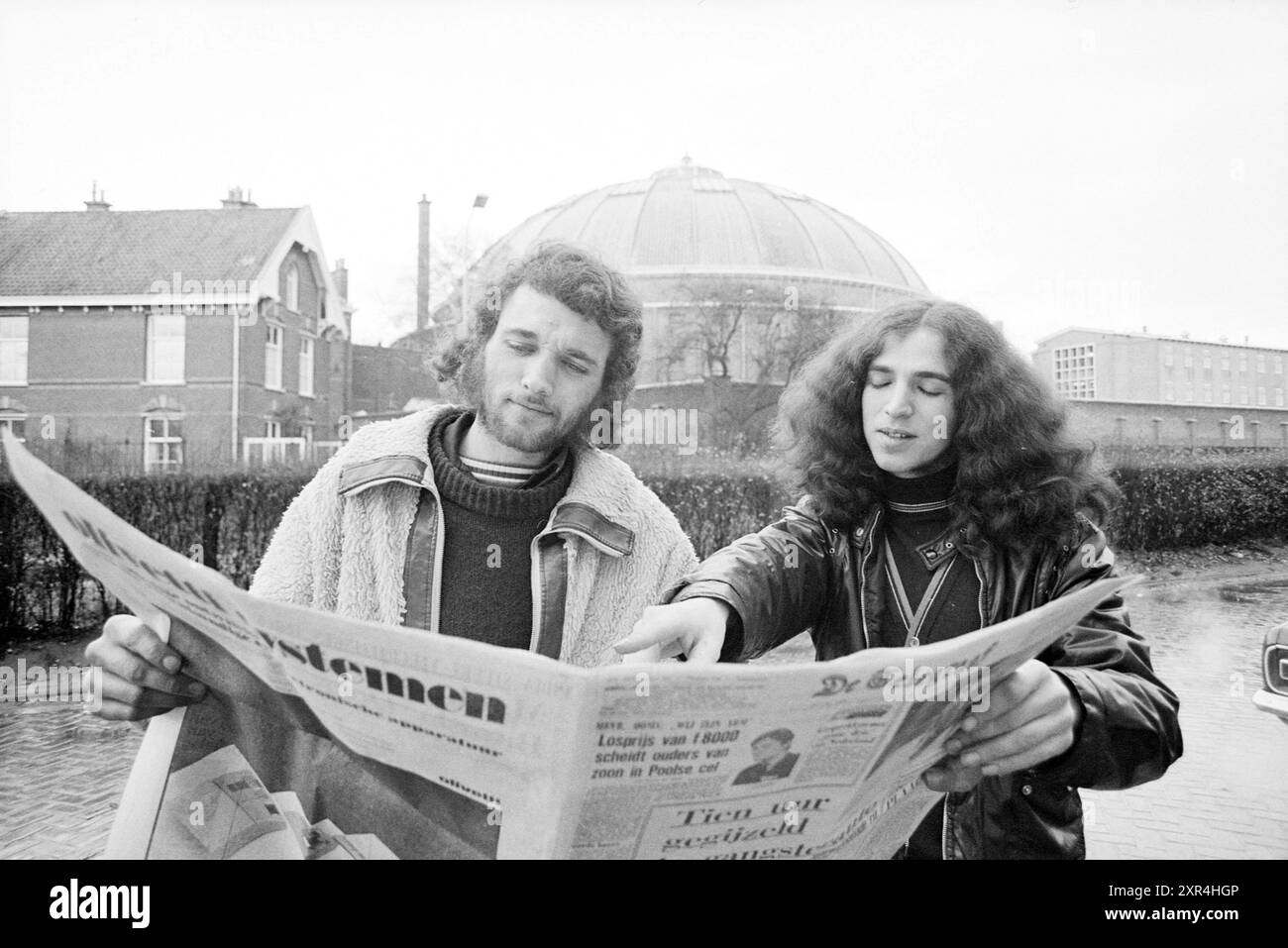 Two people with newspaper (Telegraaf) with Dome Prison in the background, Haarlem, The ...