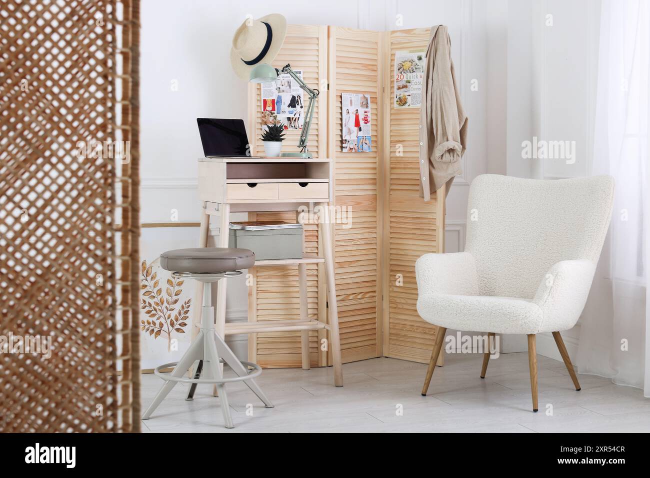 Folding screens, table, laptop, picture and armchair indoors. Interior ...