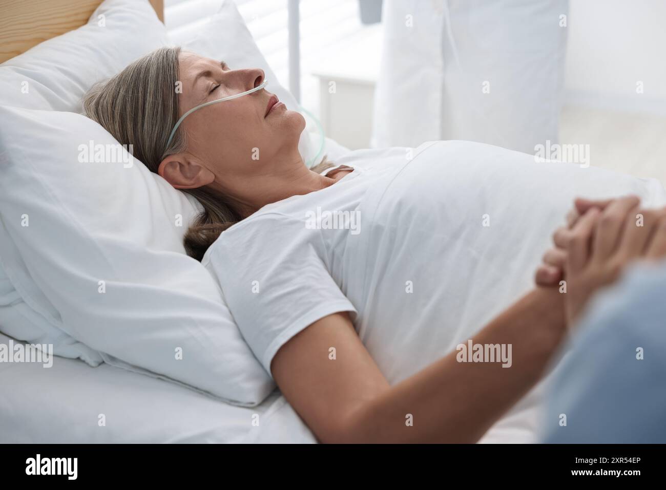 Coma patient. Man near his unconscious mother in hospital Stock Photo ...