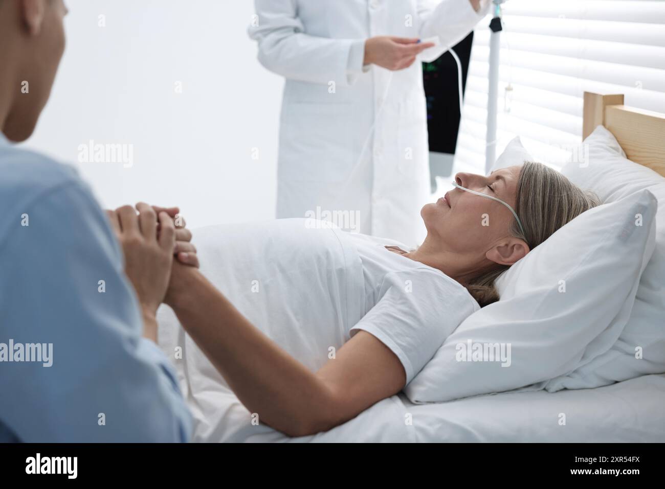 Coma patient. Man near his unconscious mother in hospital Stock Photo ...