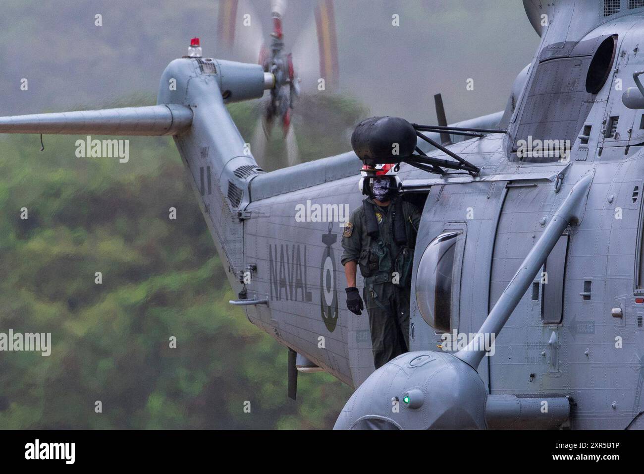 A Peruvian aircrewman checks the area surrounding a Peruvian H-3 Sea ...