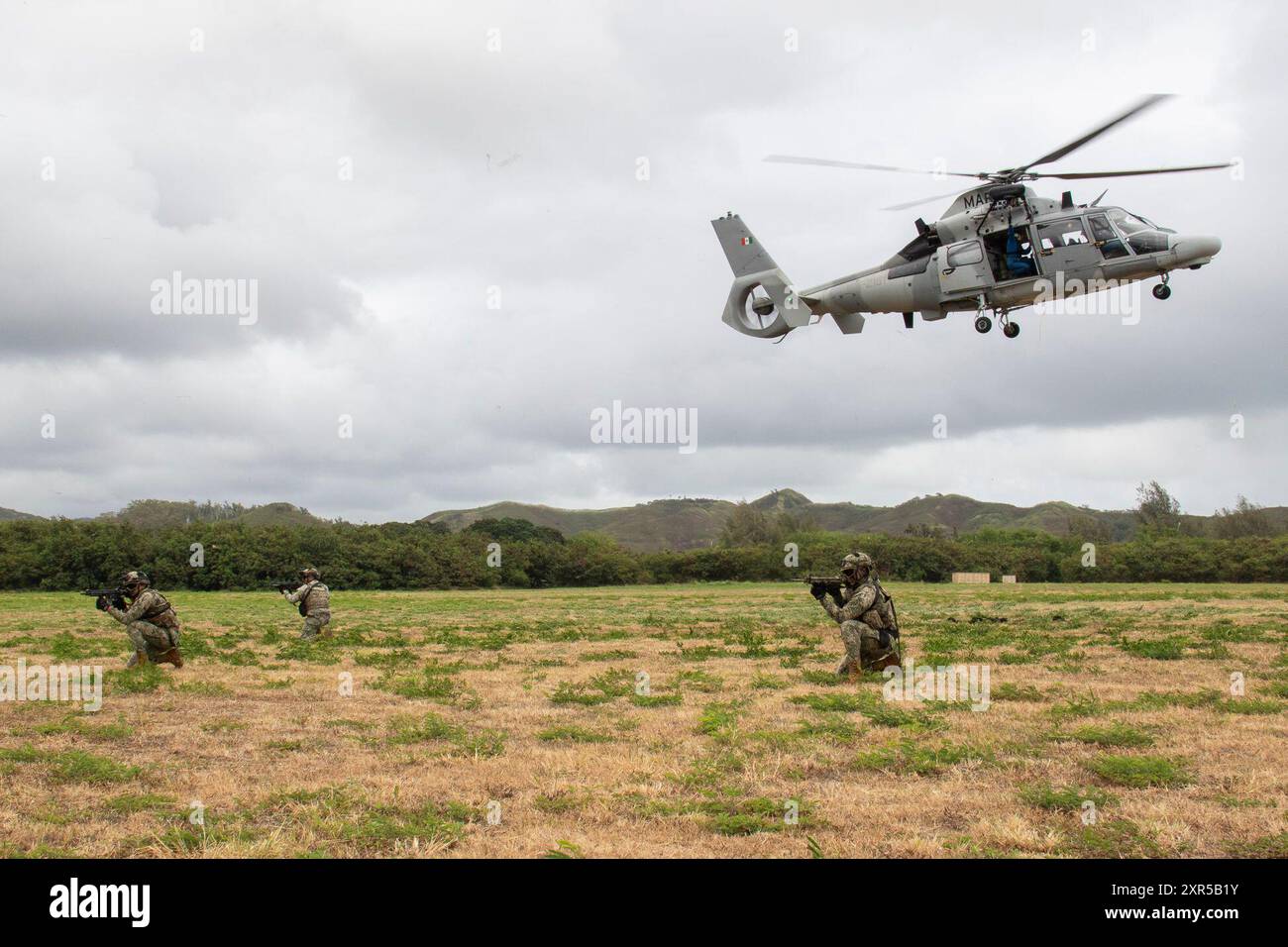 Three Mexican Marines establish security on the ground below a Mexican ...